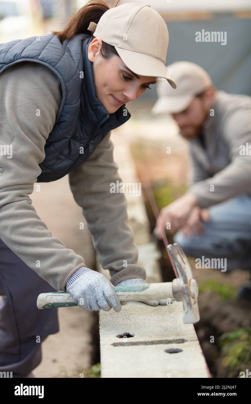 female construction worker on site hammering Stock Photo - Alamy