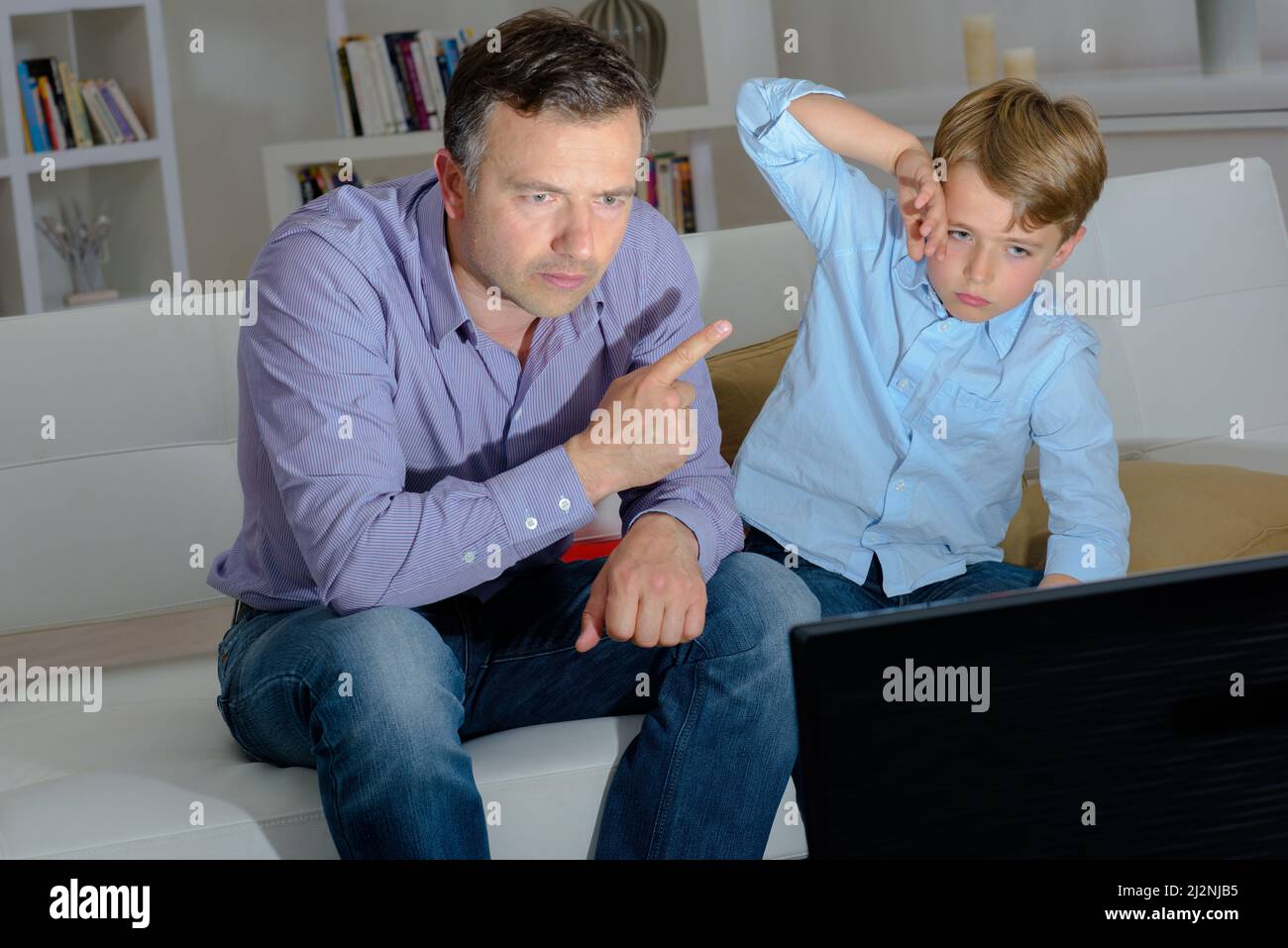 dad and his son watching television Stock Photo - Alamy