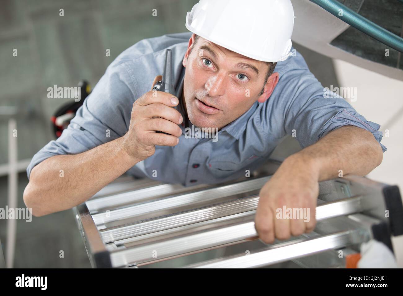 civil engineer holding walkie talkie on a ladder Stock Photo - Alamy