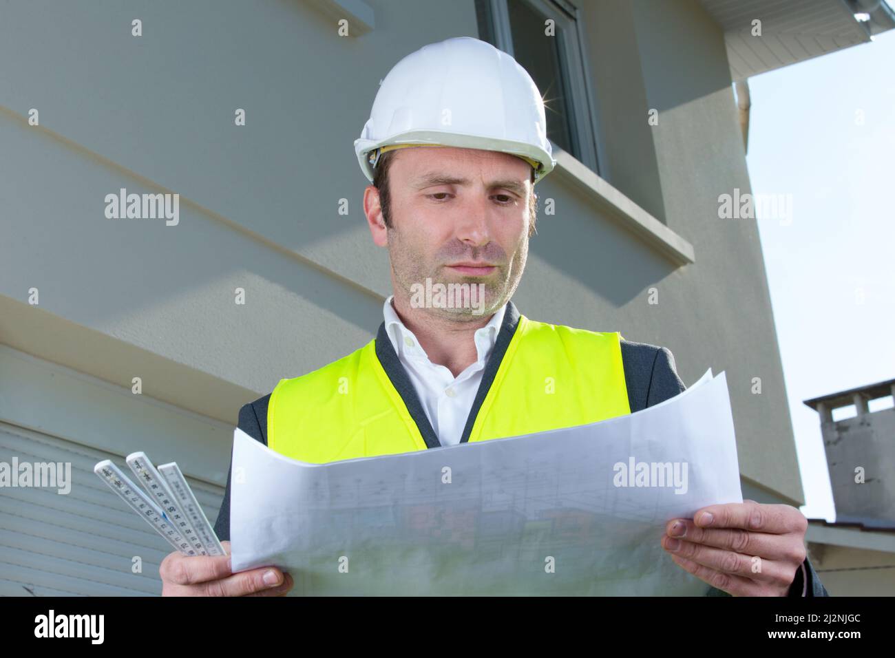 engineer man in helmet and jacket controlling outdoor construction site ...
