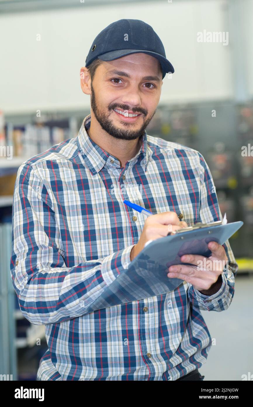 smith writing to clipboard at warehouse Stock Photo - Alamy