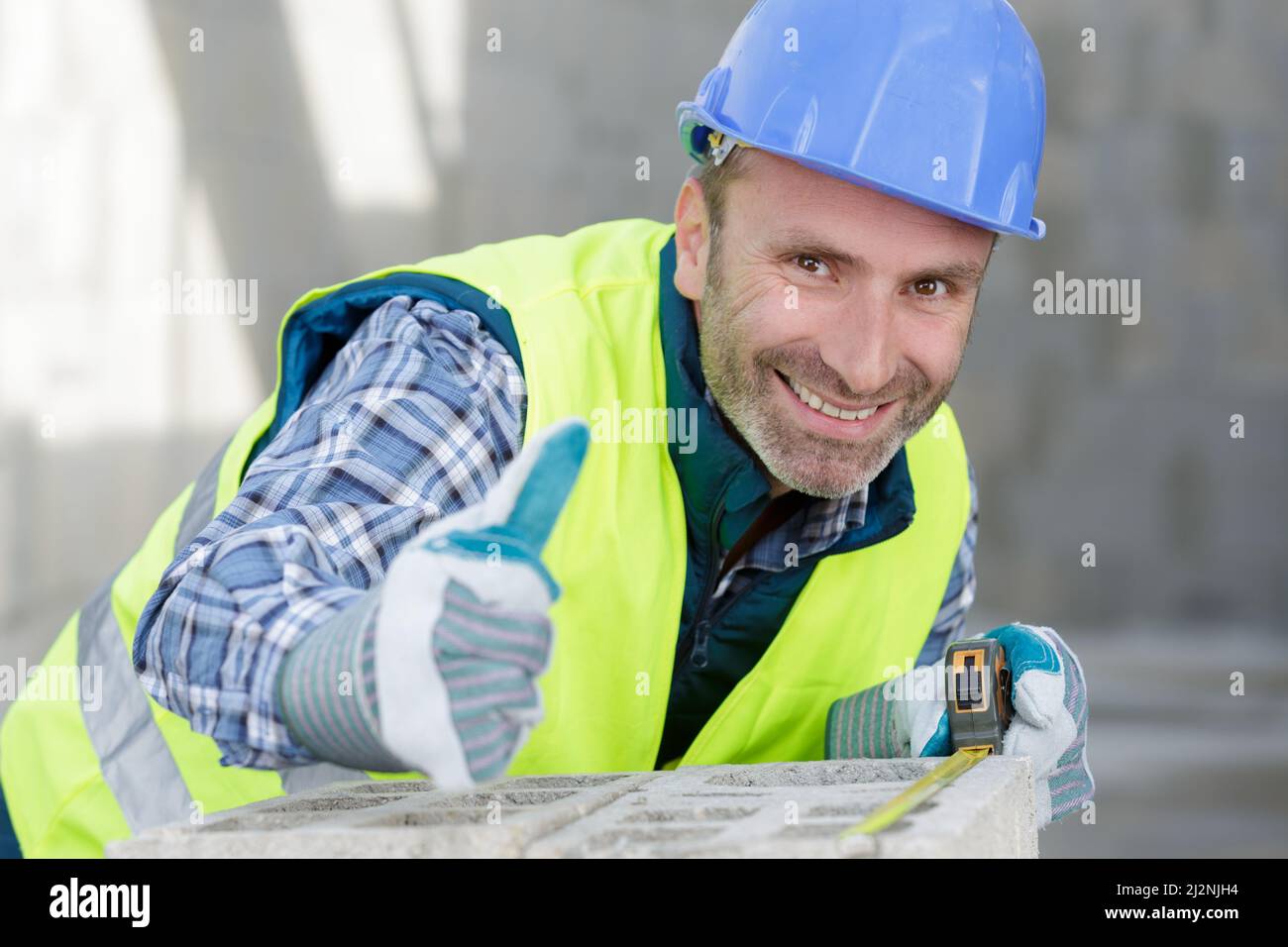 happy builder man laughing and making thumbs up at camera Stock Photo ...