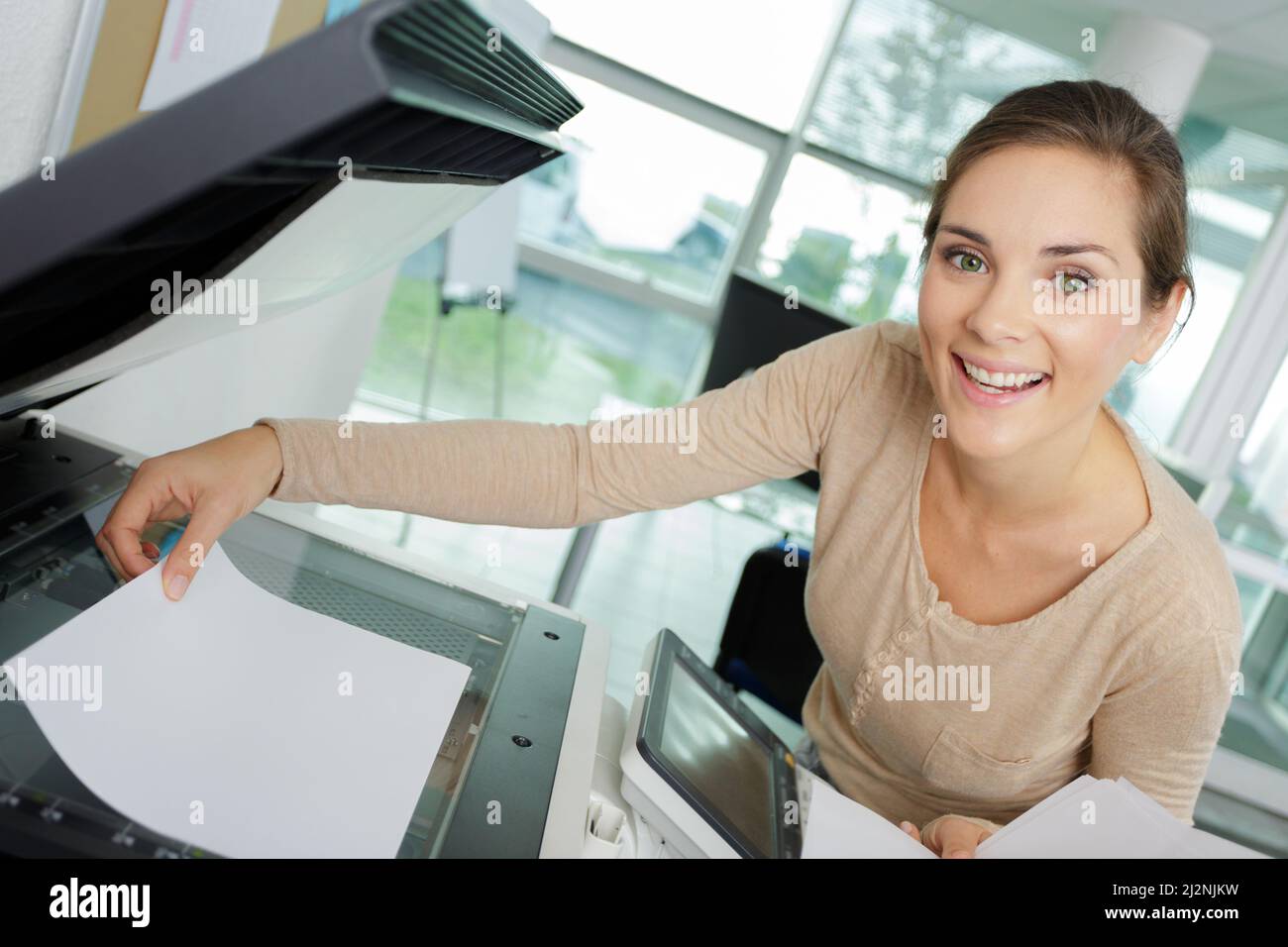smiling woman makes photocopies in office Stock Photo - Alamy