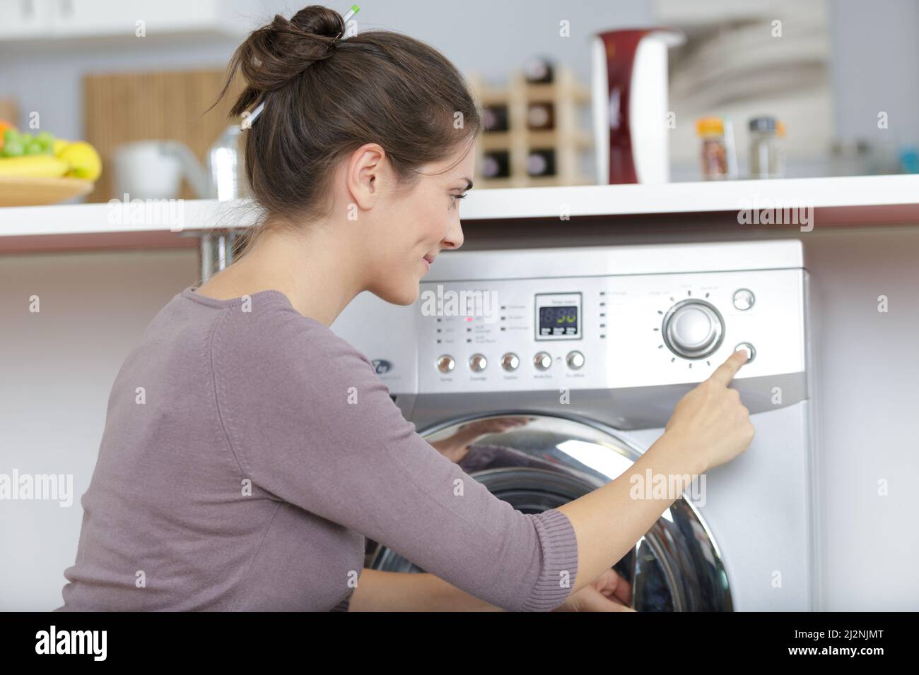 Woman using washing machine hi-res stock photography and images - Alamy