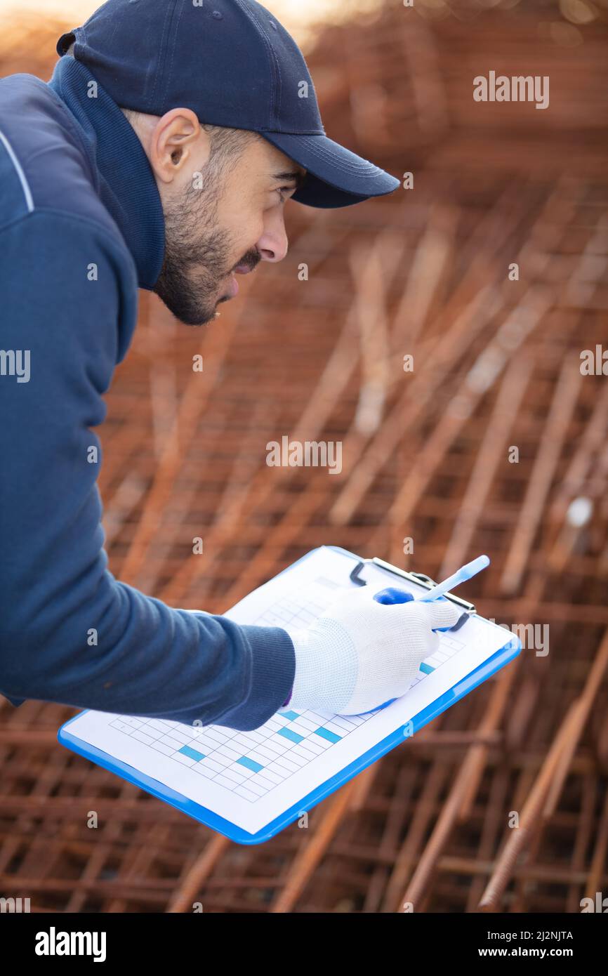 construction worker writing on clipboard Stock Photo - Alamy