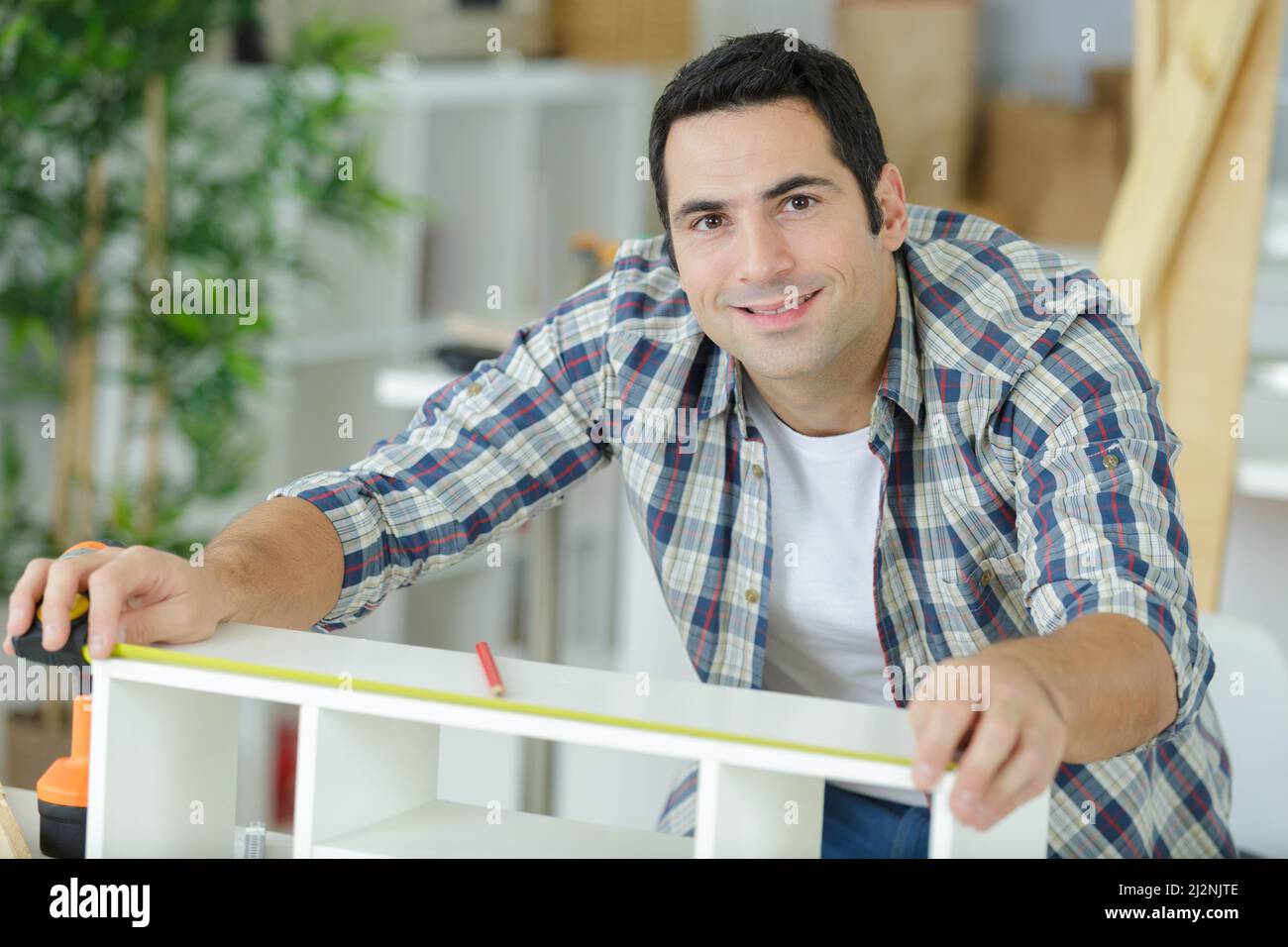 man using tape measure for measuring a furniture Stock Photo - Alamy