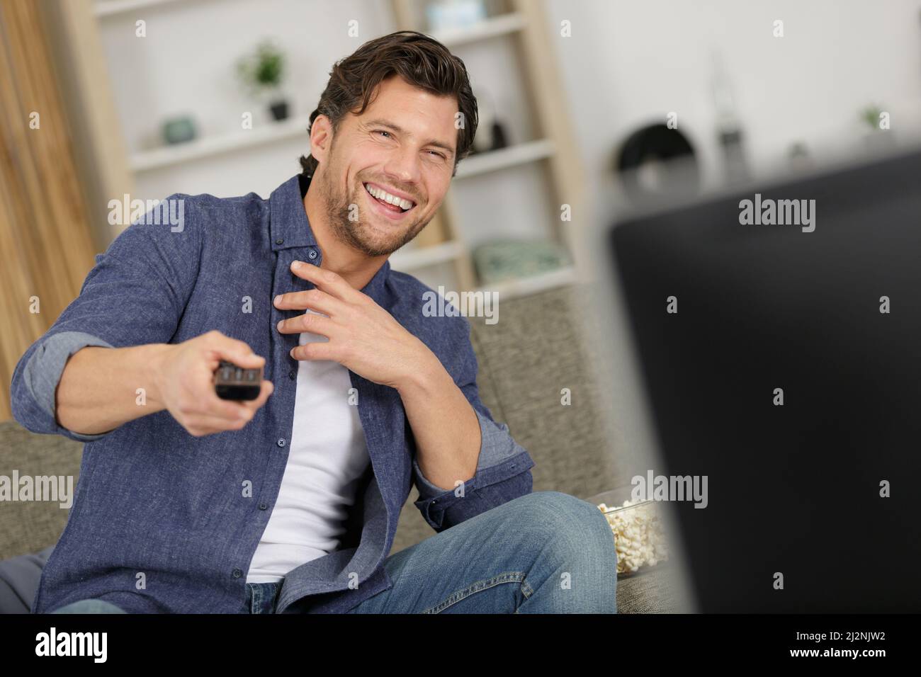 amused man watching tv at home Stock Photo - Alamy