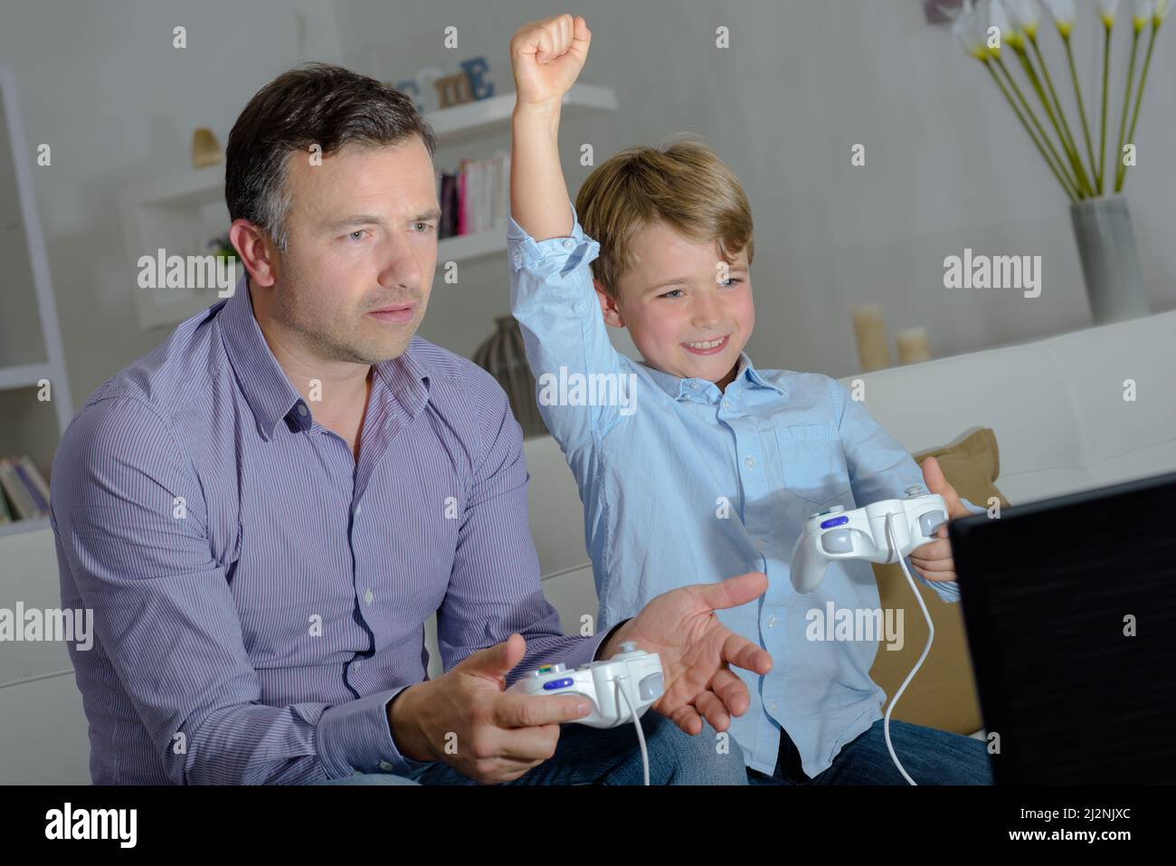 Father and son playing video game, son winning Stock Photo - Alamy