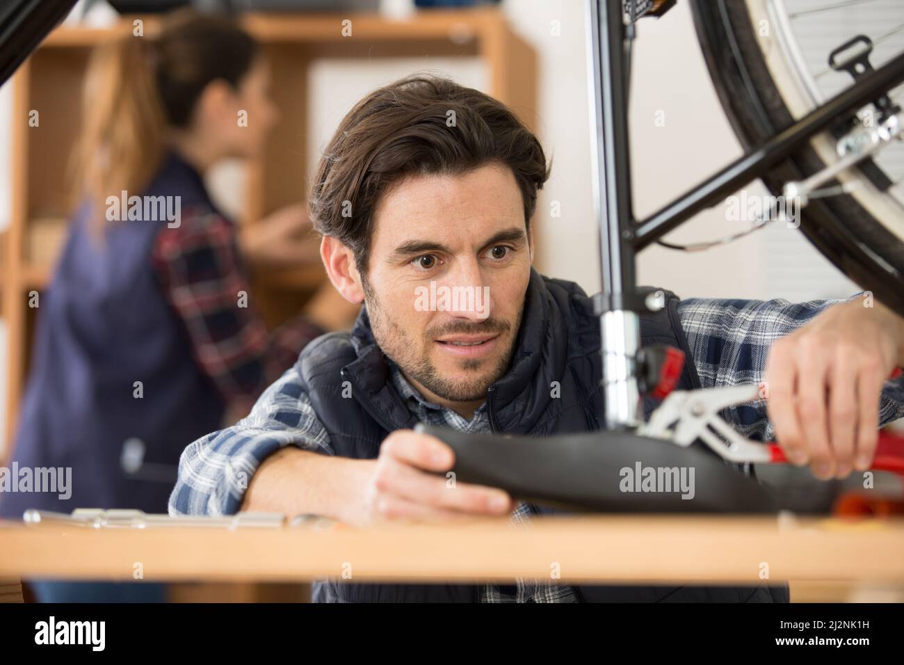 bicycle master in a workshop installing a saddle Stock Photo - Alamy