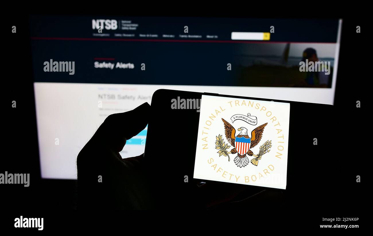 Person holding cellphone with seal of US National Transportation Safety ...