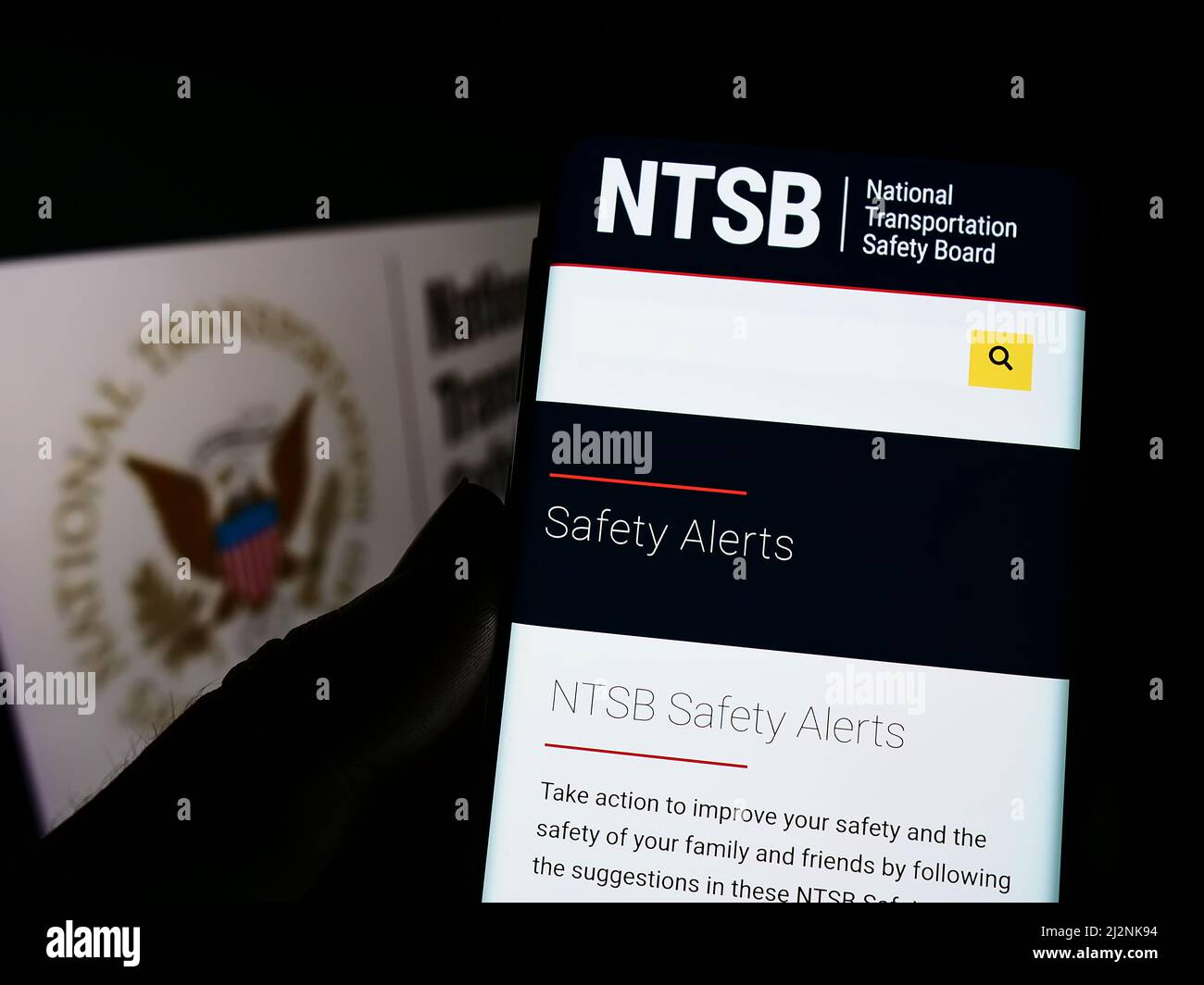 Person holding smartphone with webpage of US National Transportation ...