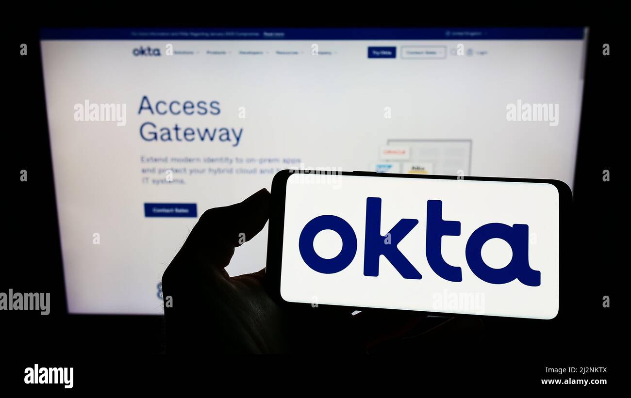 Person holding mobile phone with logo of American identity management ...