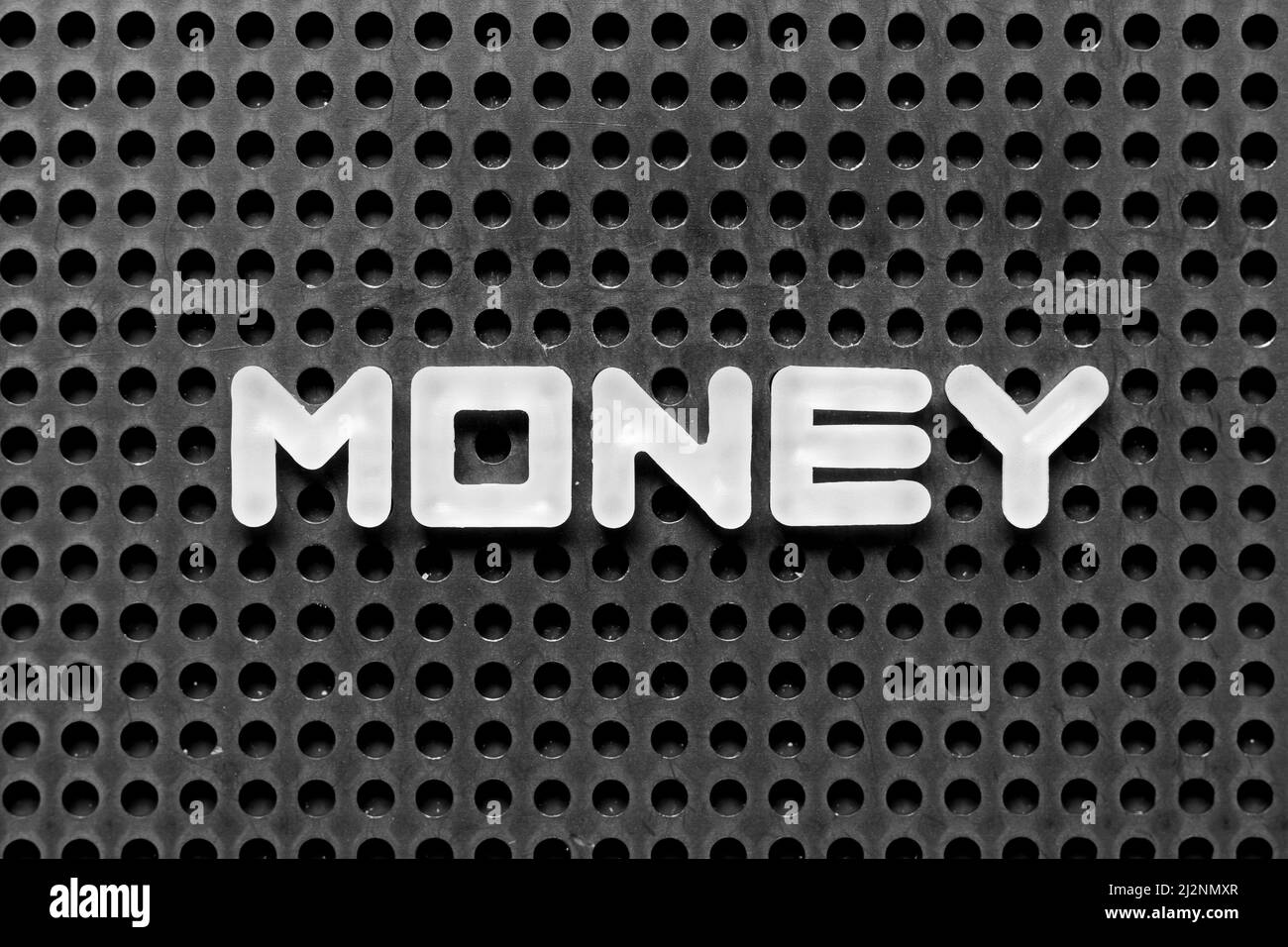 White alphabet letter in word money on black pegboard background Stock ...