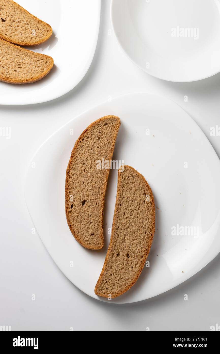 Slices of wholemeal bread in empty plates, dieting, poverty concept ...