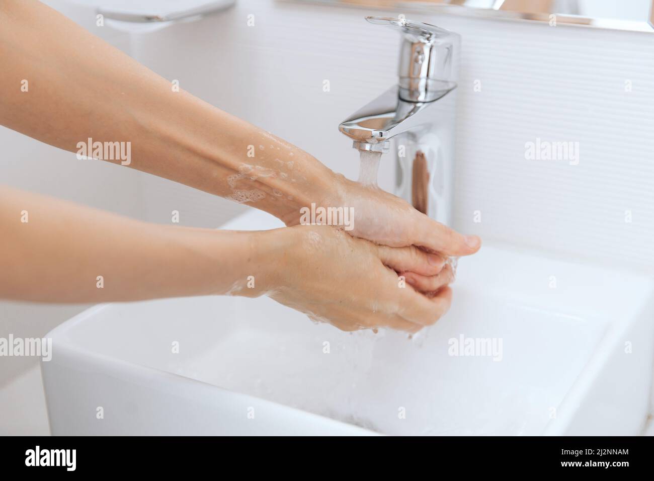 Washing hands under the flowing water tap. Hygiene concept hand detail ...
