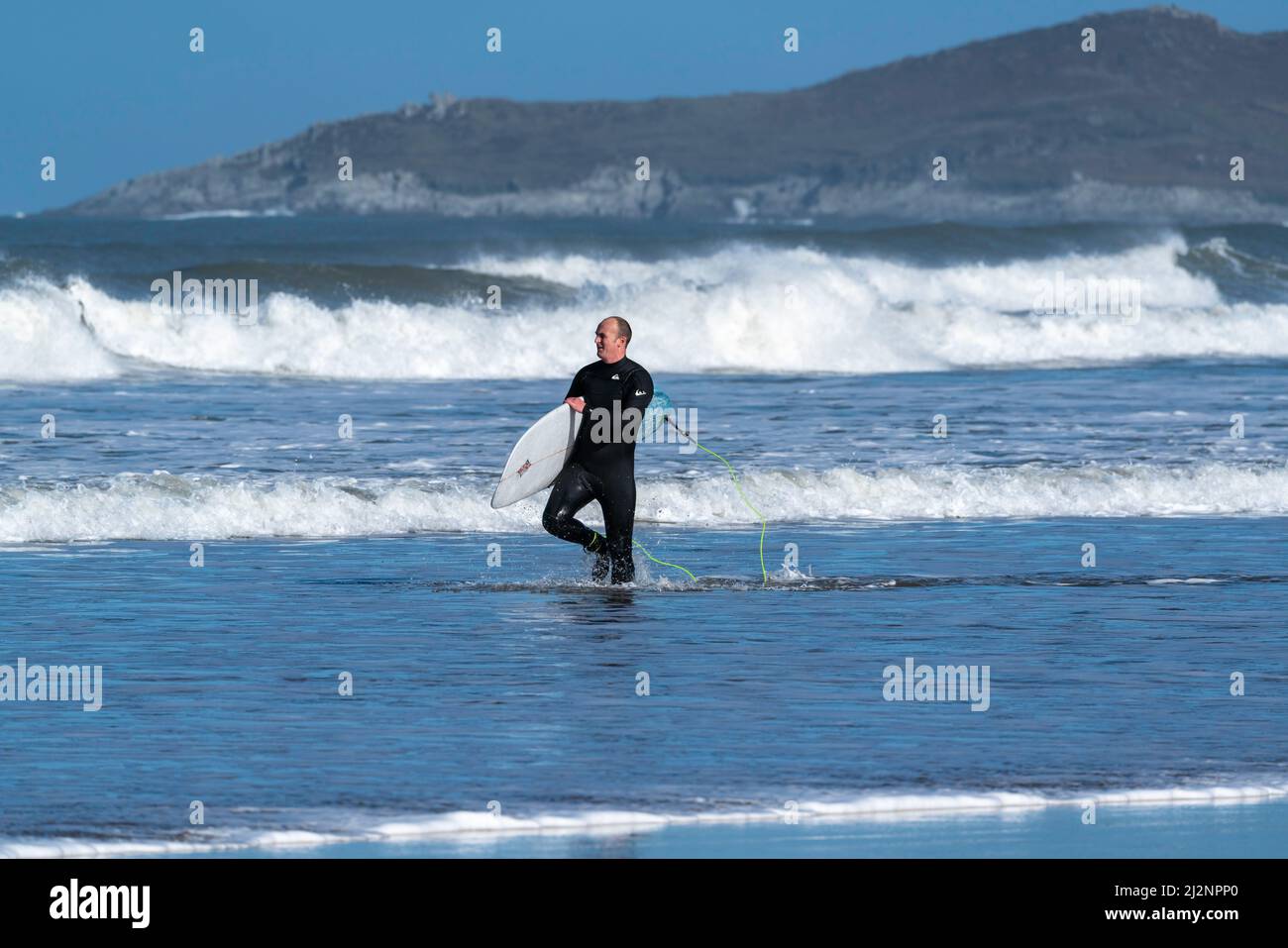 A surfer checks out the waves at Putsborough, North Devon, United ...