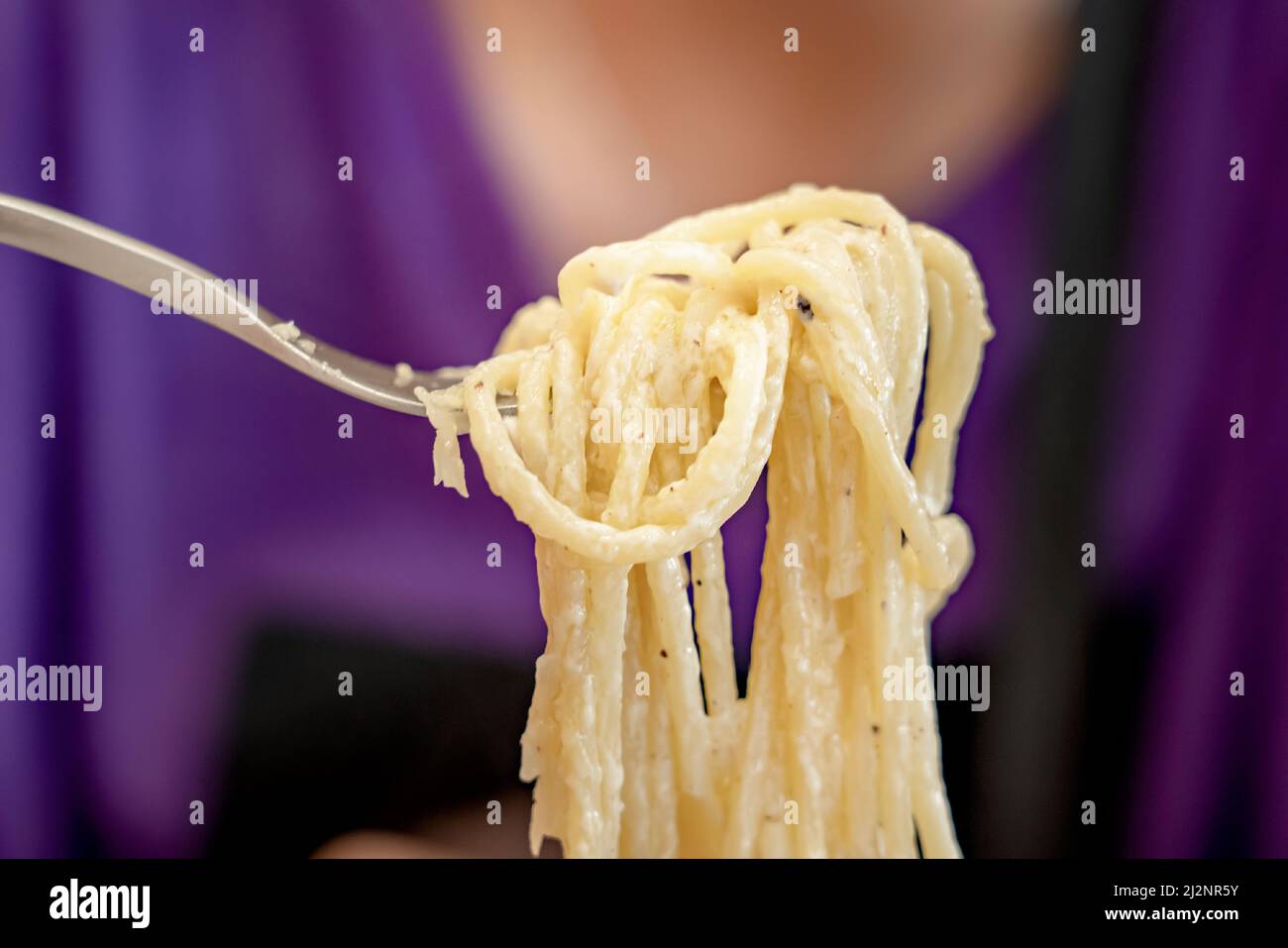 Egg yolk Pasta alla Carbonara. A fork spindles from a bowl of linguine ...