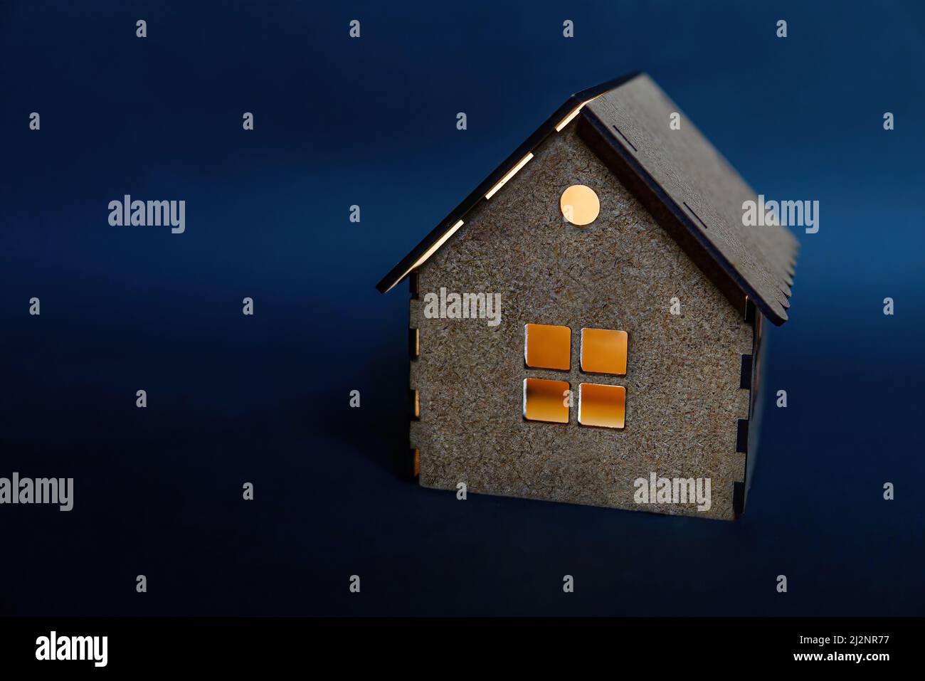 Miniature cardboard house model illuminated from inside. Sweet home ...