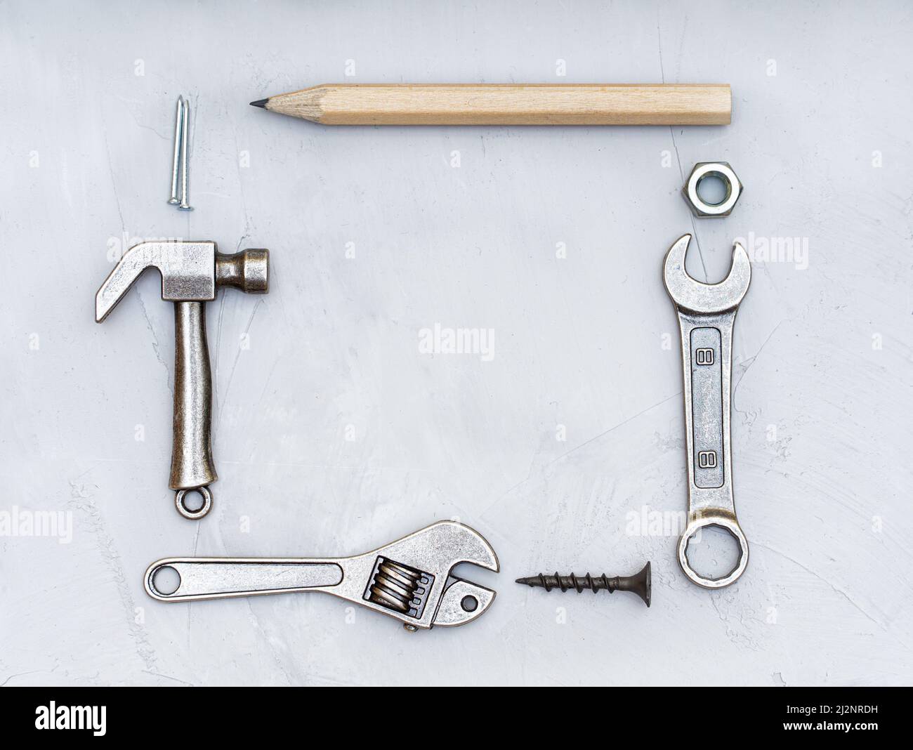 Set of miniature copies of essential hand tools and fasteners arranged ...