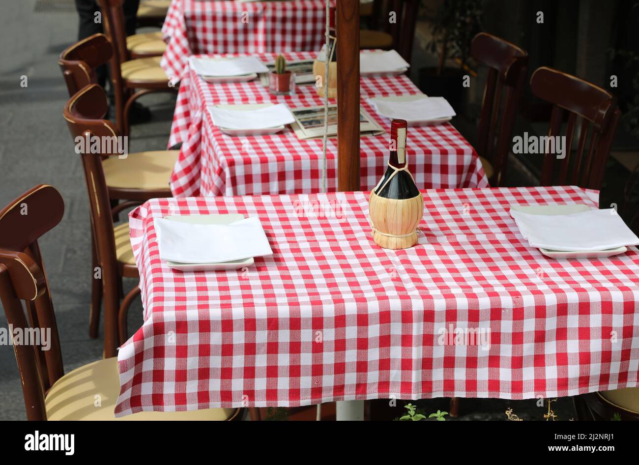 tables of an alfresco restaurant with red and white checkered ...
