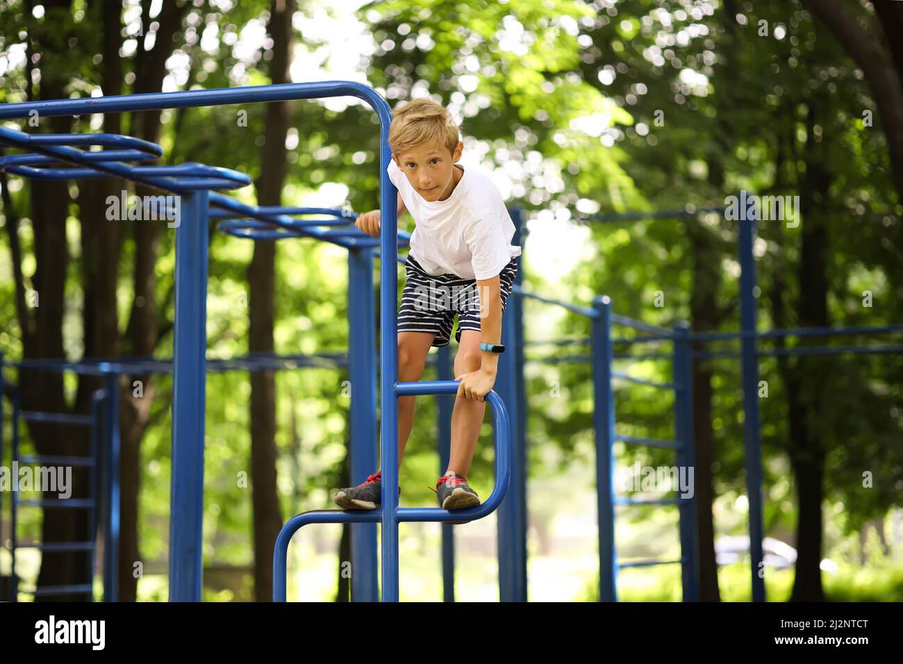 the boy athlete is in the park on the sports ground climbed on the ...