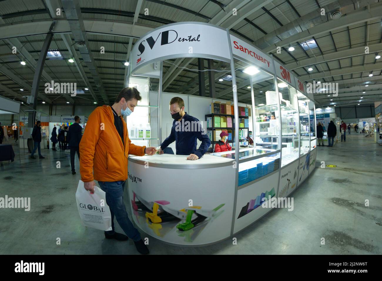 Manager consulting visitors, stand with medical goods and equipment ...