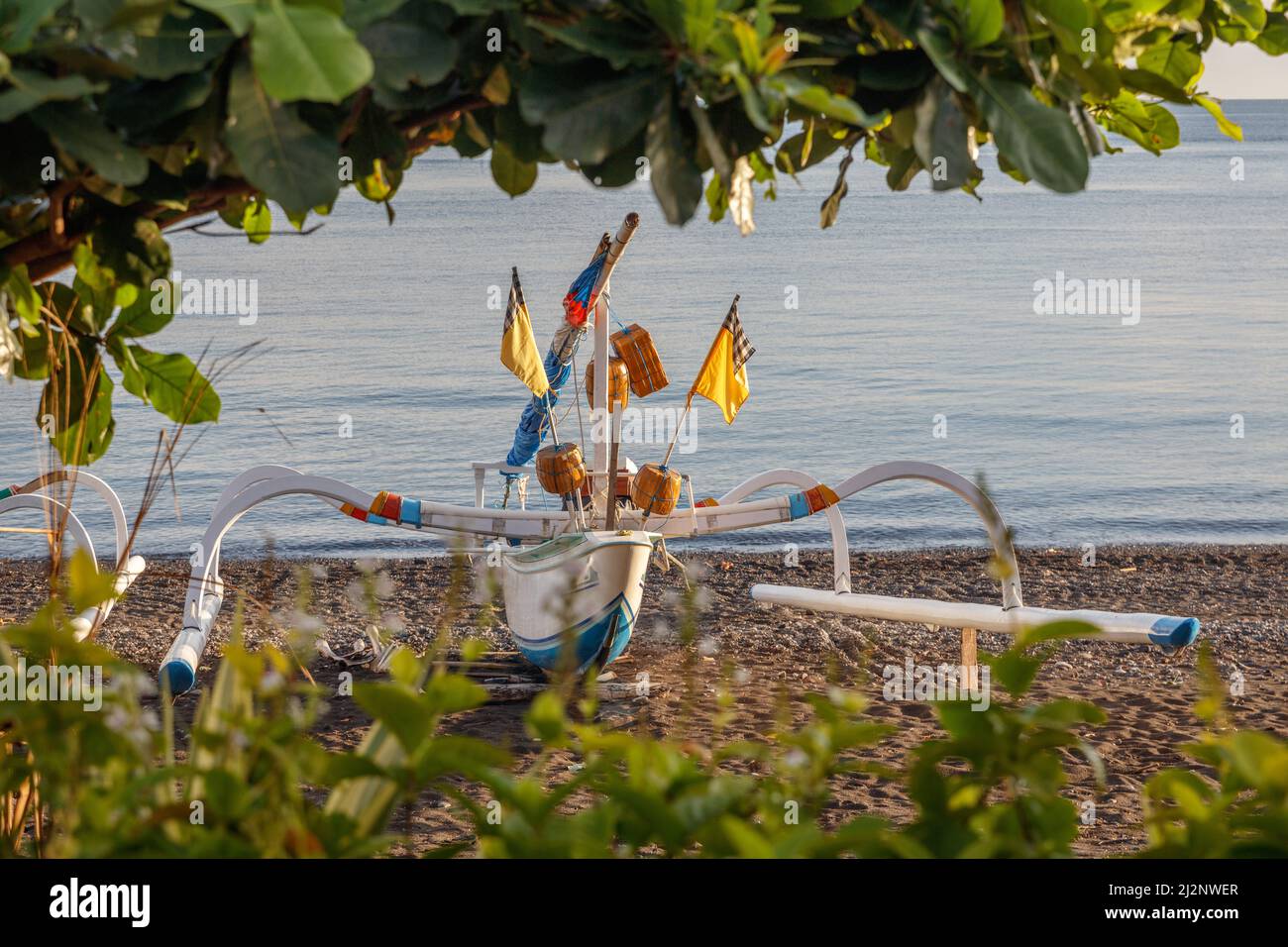 Traditional Indonesian outrigger style wooden fishing boat (jukung) in ...