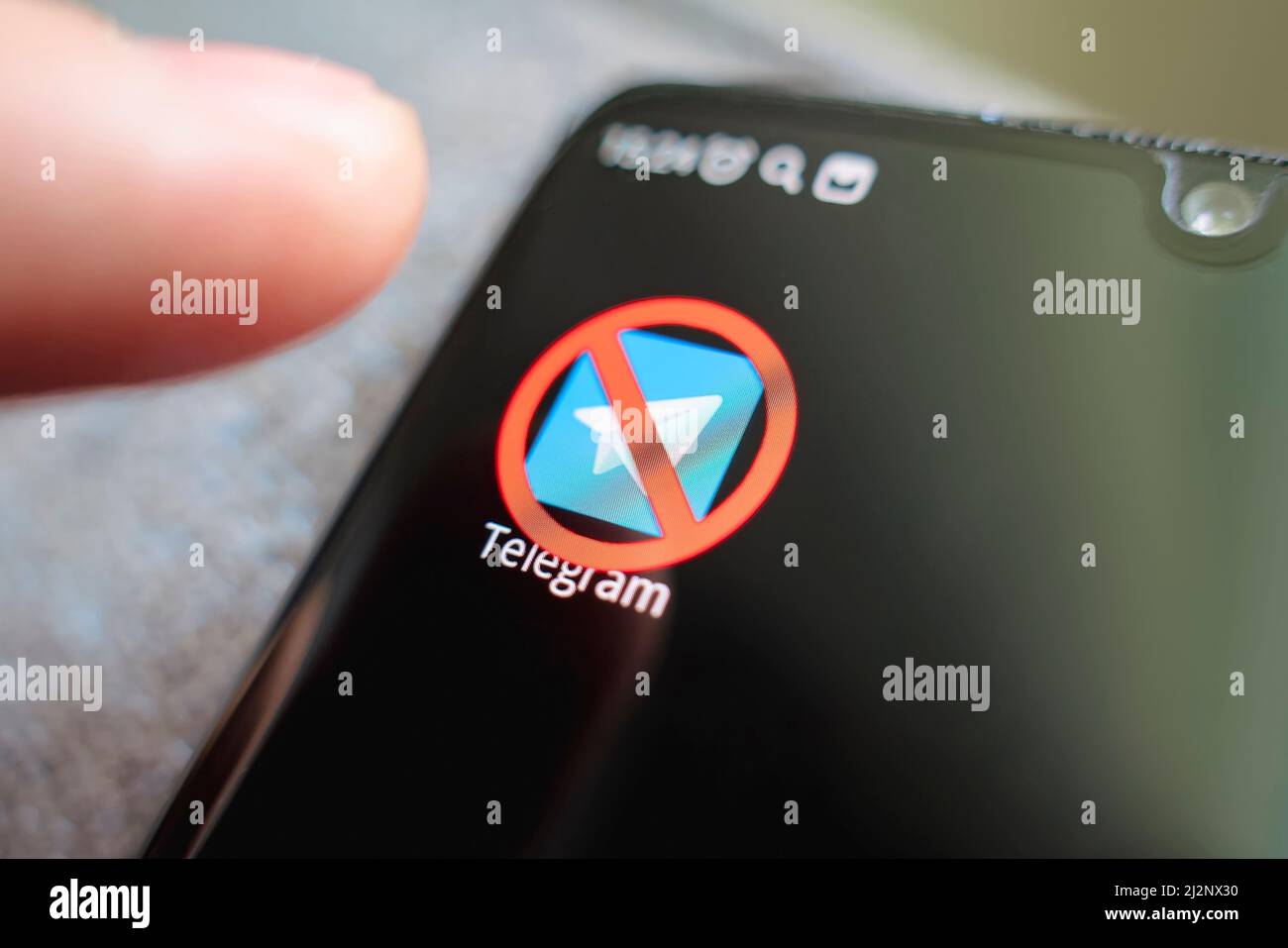 A crossed-out icon on a black smartphone screen. the concept of banning ...