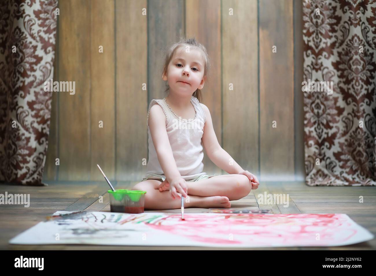Little children paint on a large sheet of paper on the floor Stock ...