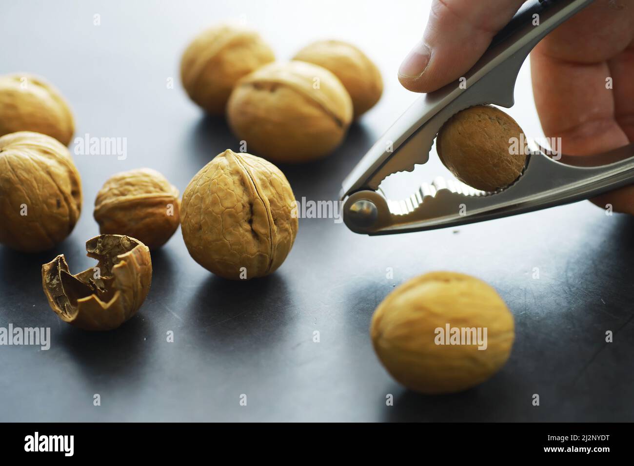 Walnuts in a shell on gray background. Nutcracker and scattering of ...