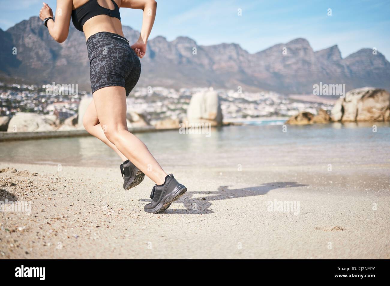 Shes setting a strong pace. Low angle shot of an unrecognizable athletic young woman out for a ...