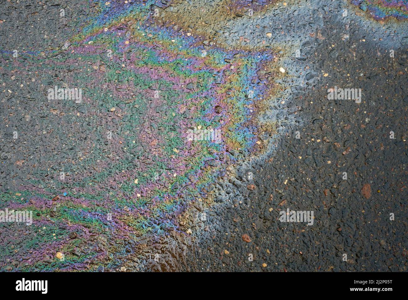 Gasoline spill on asphalt in a car park as a texture or background ...