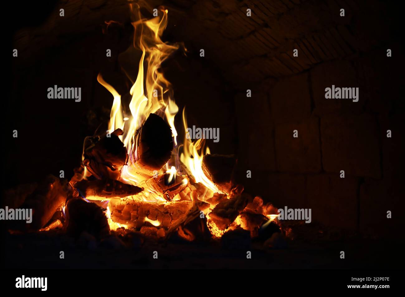 Background of the flame in the oven. Tongues of fire in brick fireplace ...