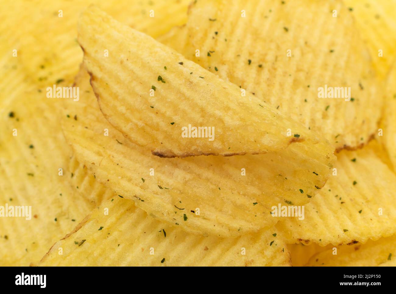 Corrugated potato chips close-up. Chips with additives and spices Stock ...