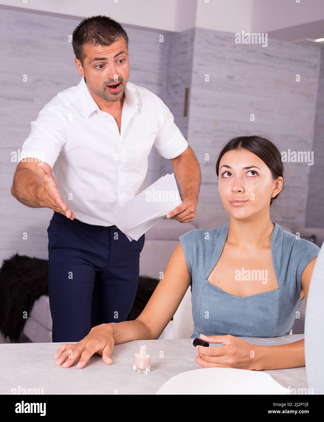 Husband scolding wife painting nails Stock Photo - Alamy