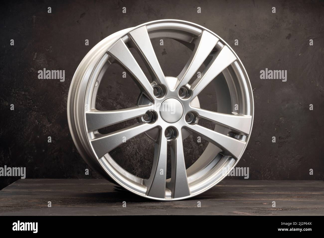 new grey alloy wheels on a dark textured black background. a wheel for ...