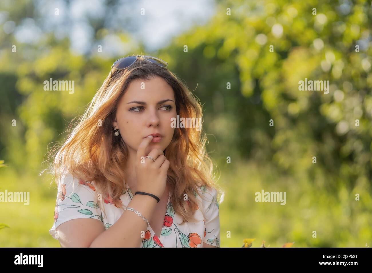 Thoughtful atractive beautiful young woman is posing outdoors ...