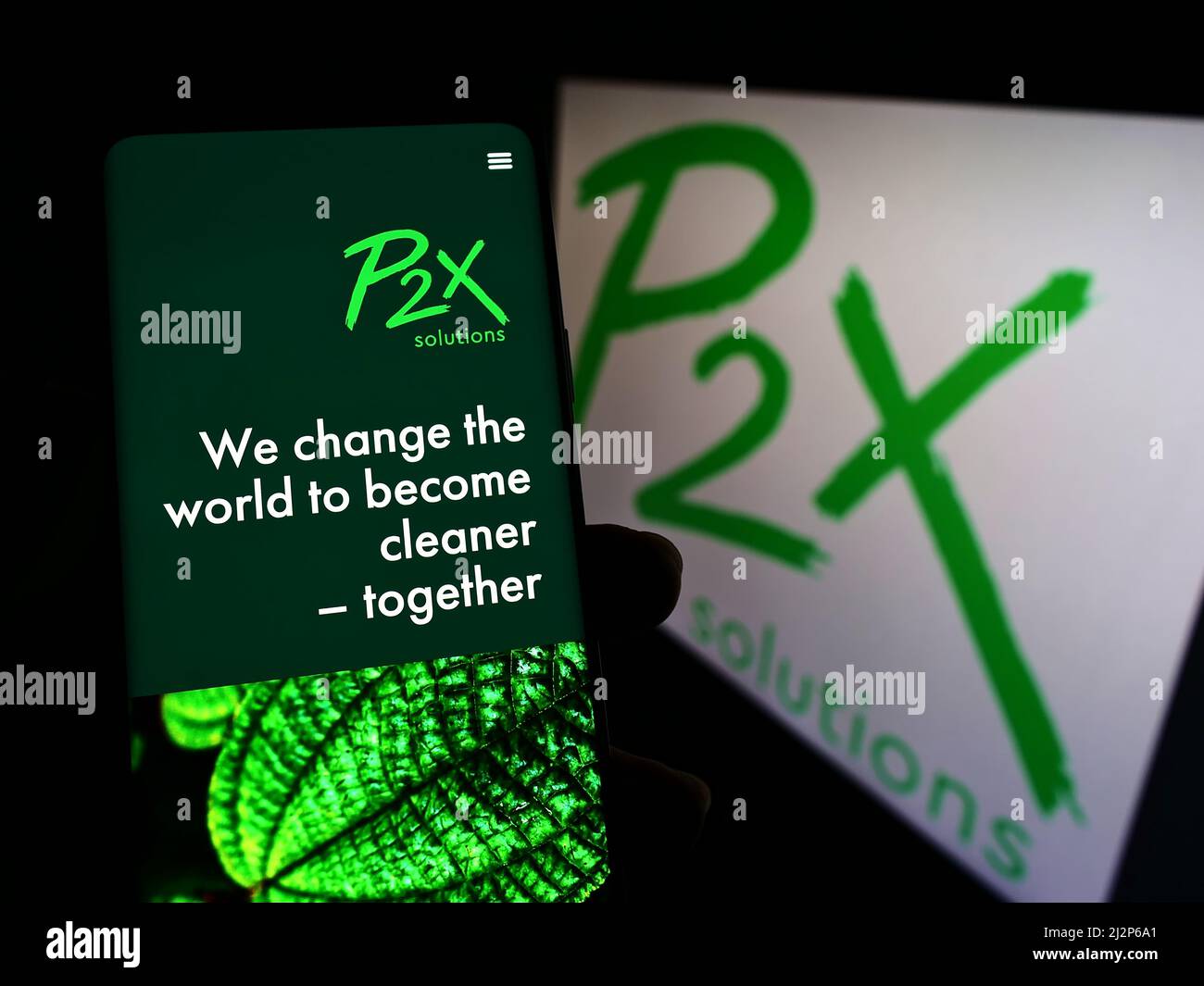 Person holding smartphone with website of Finnish energy company P2X ...