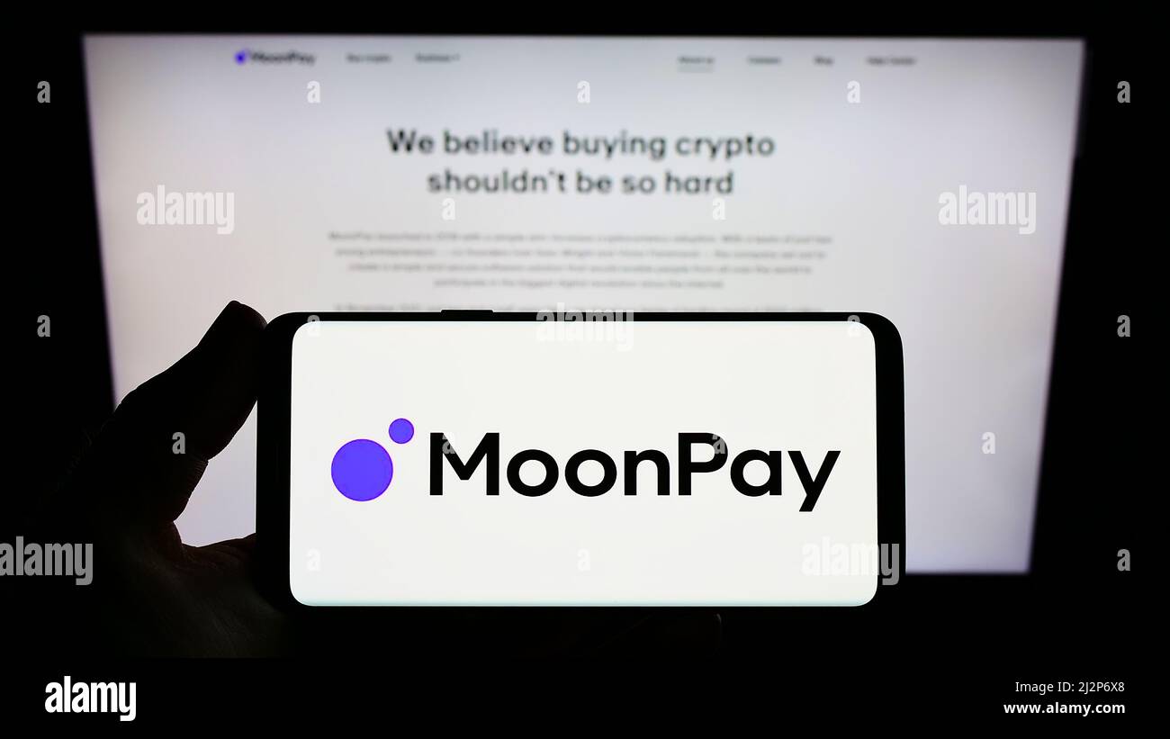 Person holding smartphone with logo of crypto company Moon Pay PTE ...