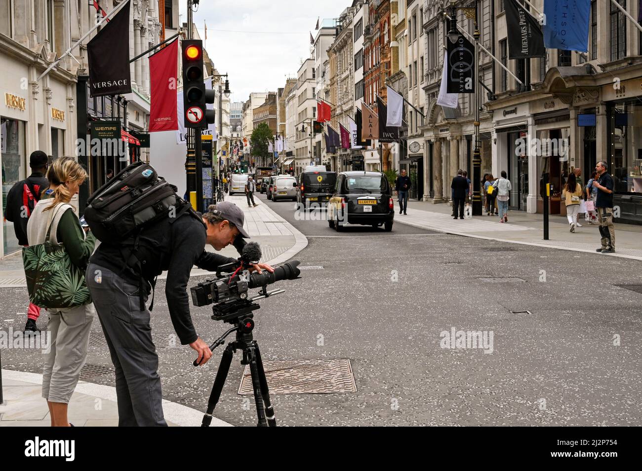 London, England - August 2021: Person using a video camera on a tripod ...