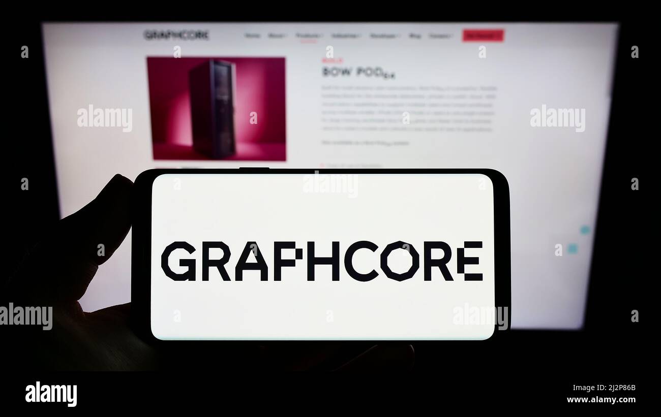 Person holding smartphone with logo of British semiconductor company Graphcore Limited on screen ...