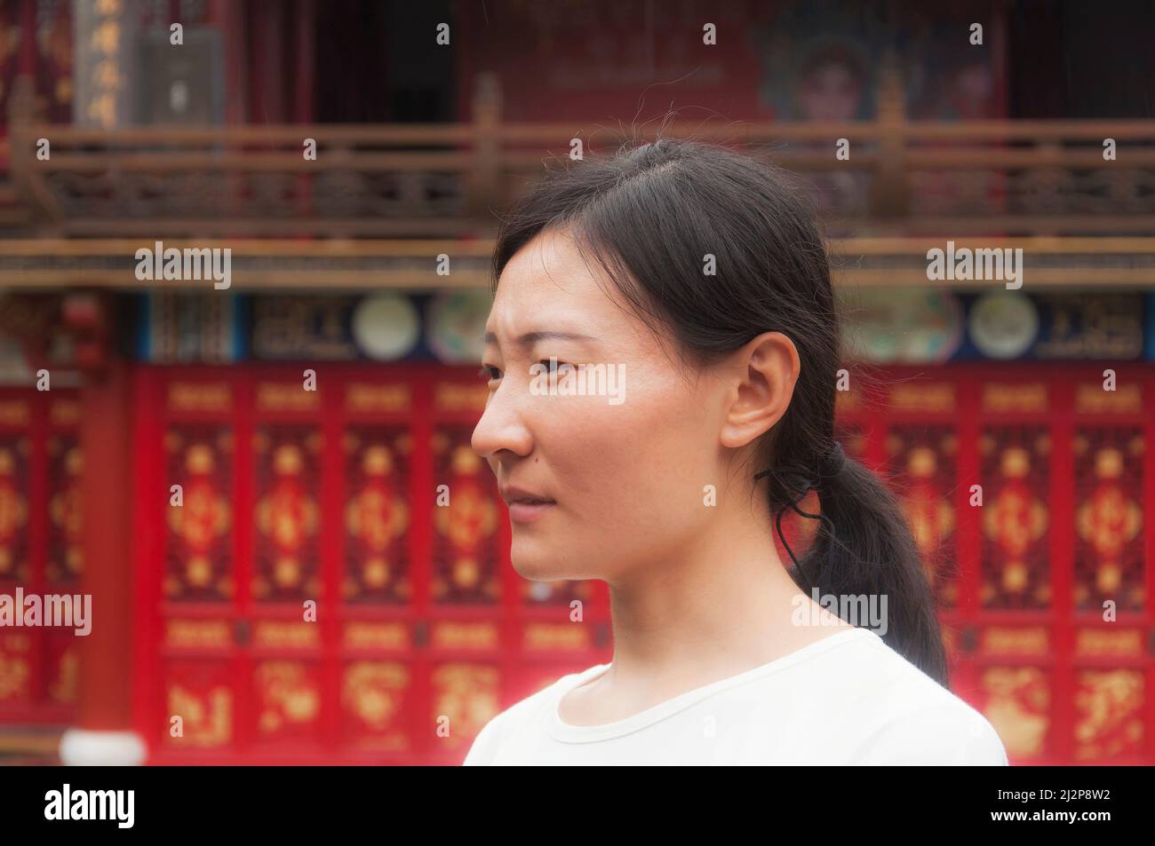 A chinese woman with a confused look, looking off to the side in front ...