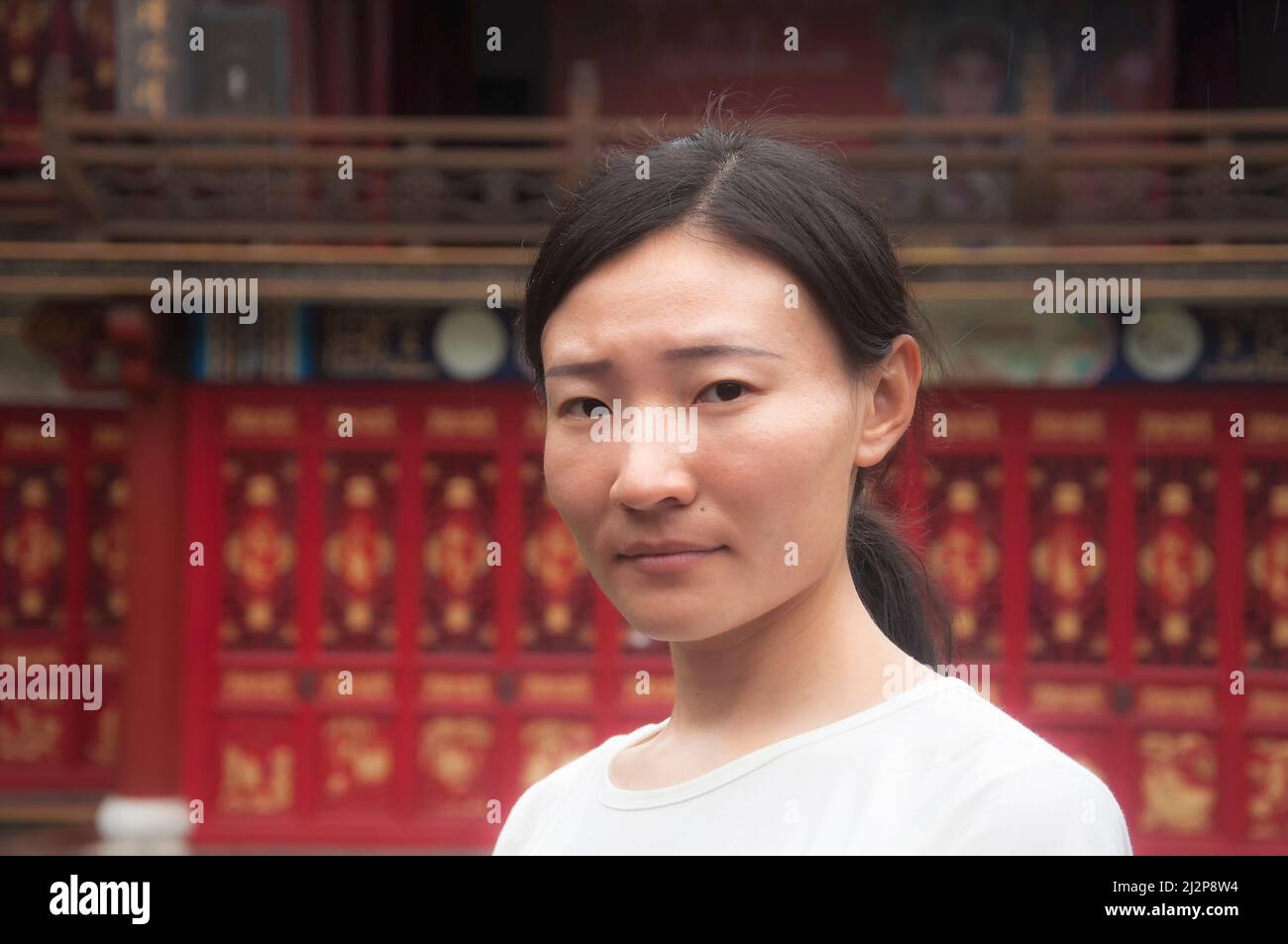 A chinese woman with a stern look in front of a performance stage with ...