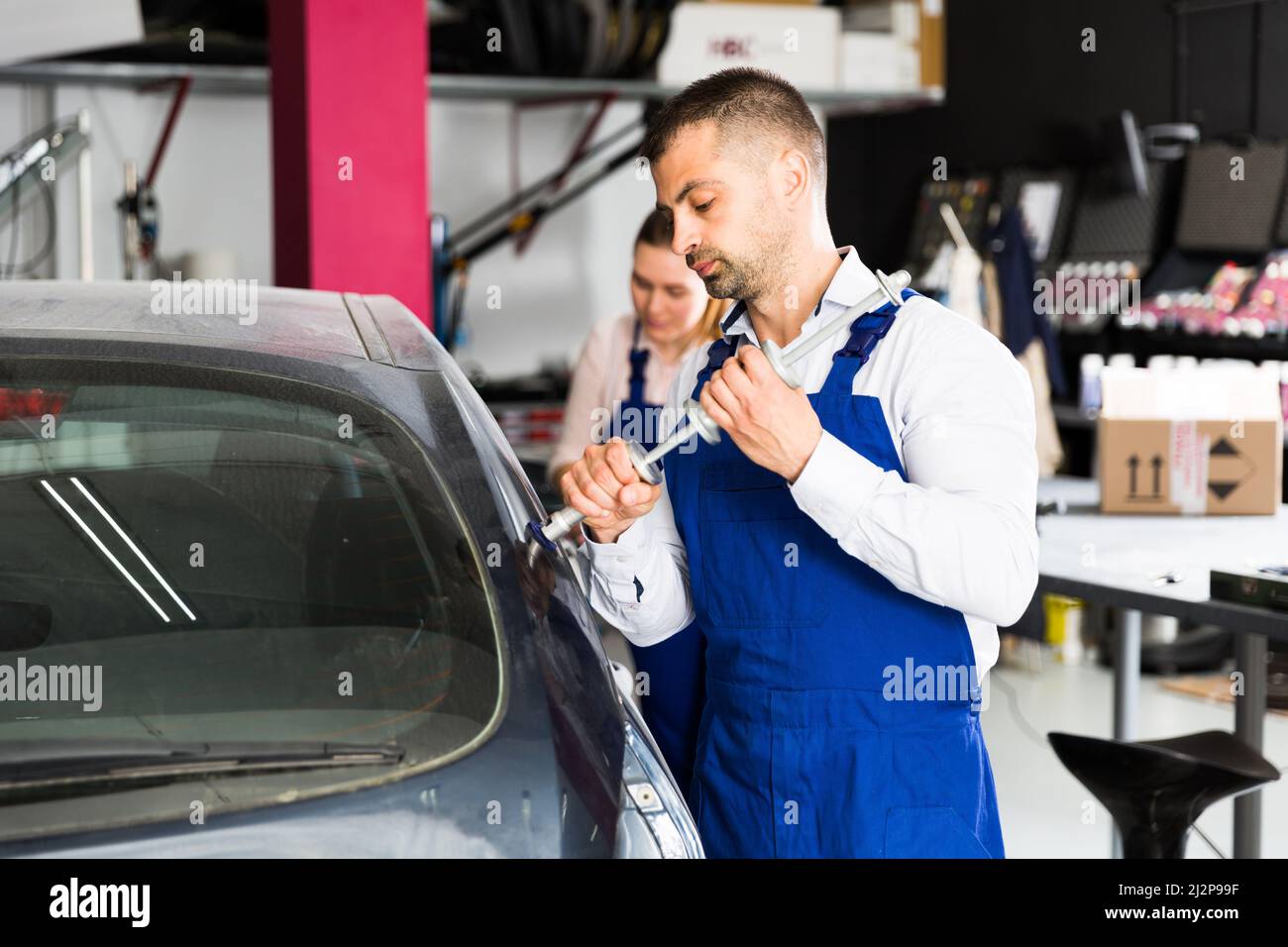 Mechanic performing dents repair Stock Photo - Alamy