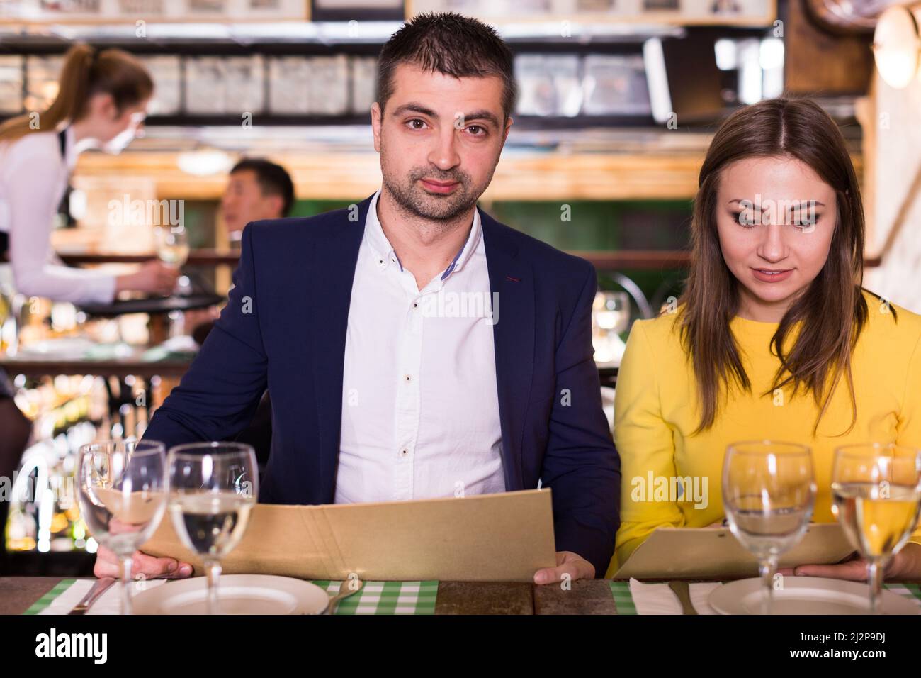 Female and male are looking in menu for order dinner Stock Photo - Alamy