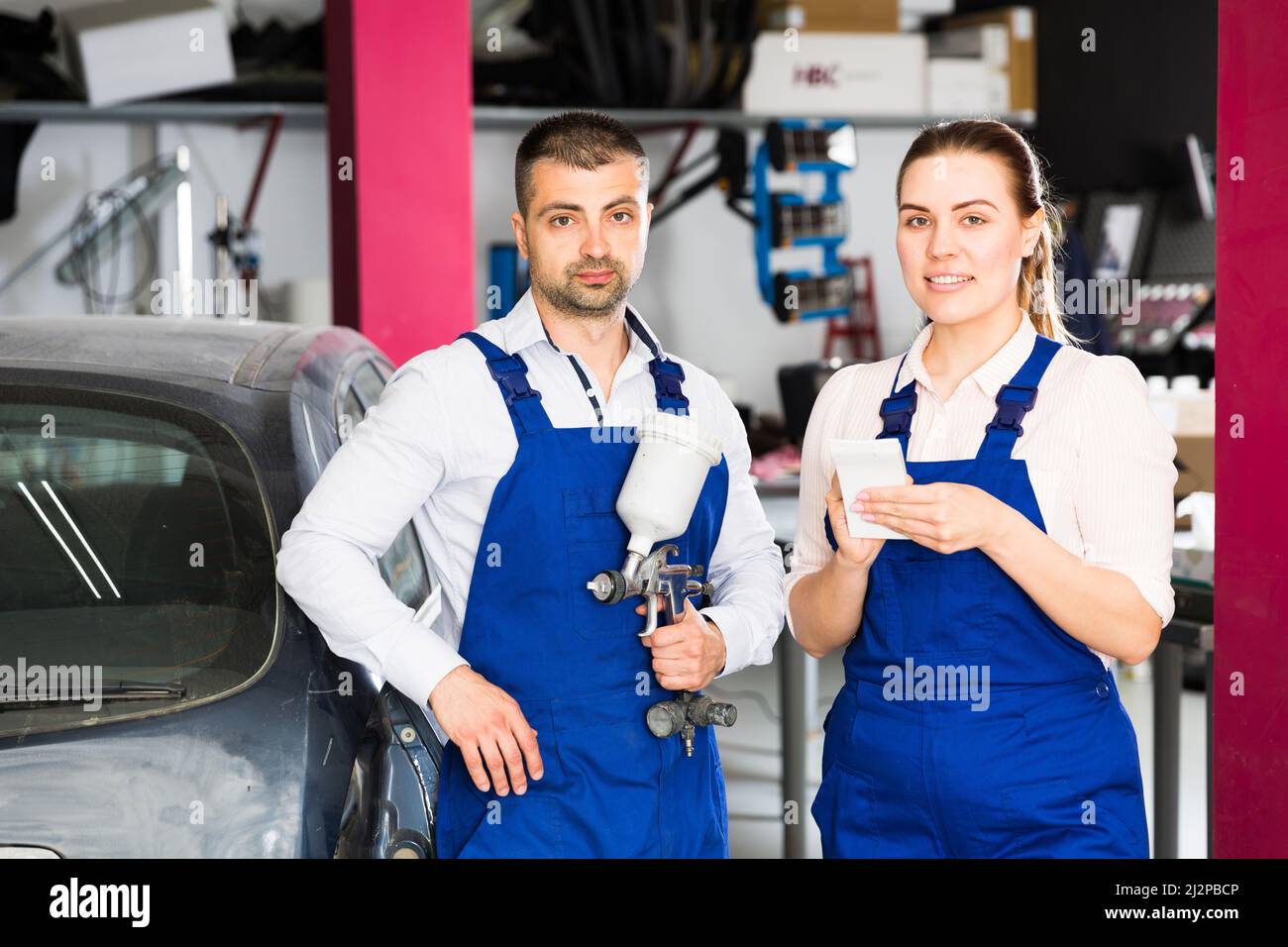 Two mechanics discussing list of works Stock Photo - Alamy