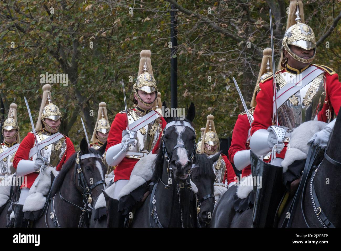 The Household Cavalry Mounted Regiment holding swords on horseback in ceremonial uniforms at the ...