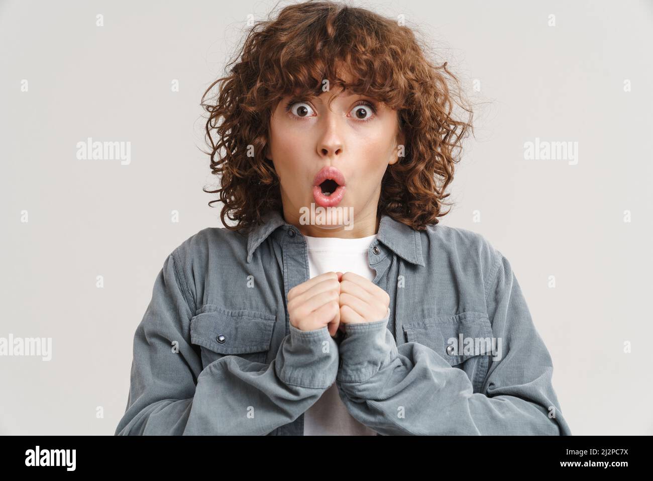 Young Ginger Shocked Woman Expressing Surprise At Camera Isolated Over