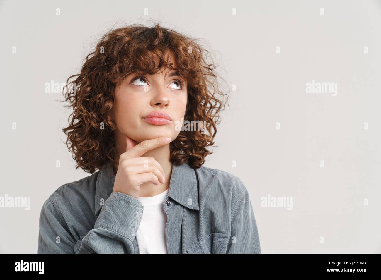 Young ginger serious woman thinking and looking upward isolated over ...