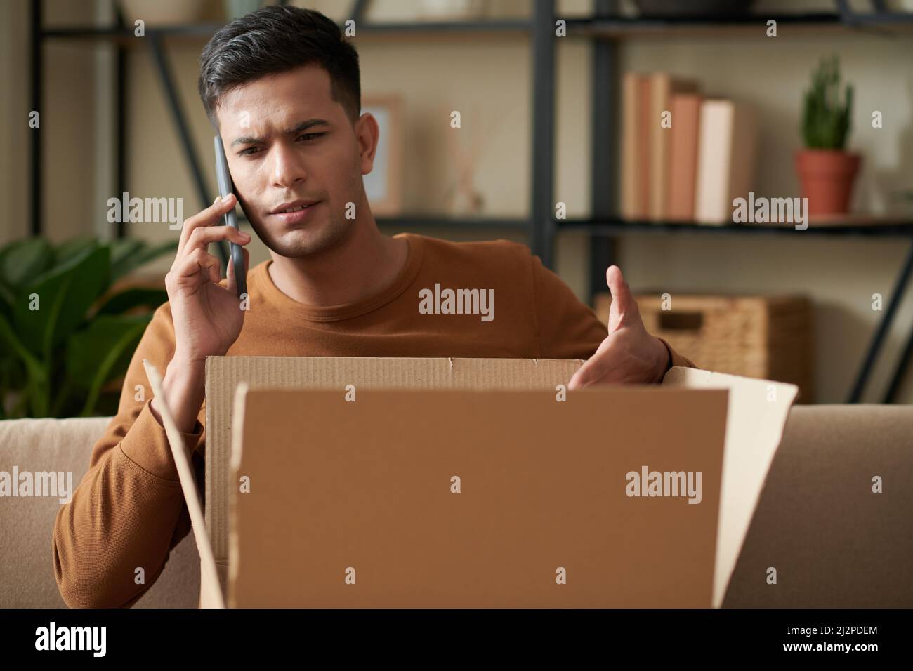 Angry young man calling to delivery service after receiving wrong ...